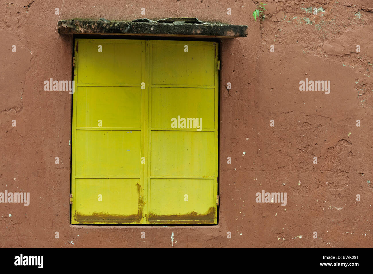 Yellow shuttered window on a terracotta wall Stock Photo - Alamy
