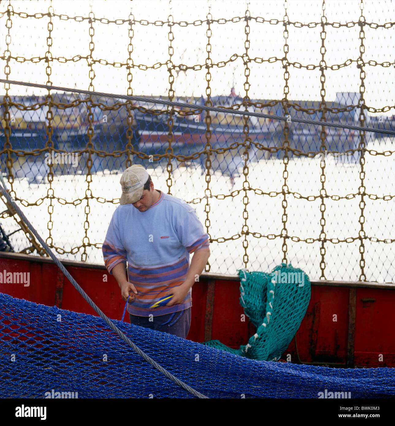 Net fisherman fixing netting boat newyln harbour hi-res stock ...