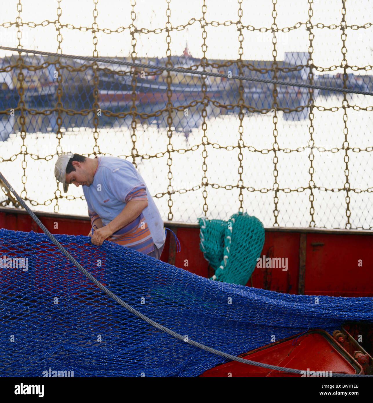 Net fisherman fixing netting boat newyln harbour hi-res stock ...