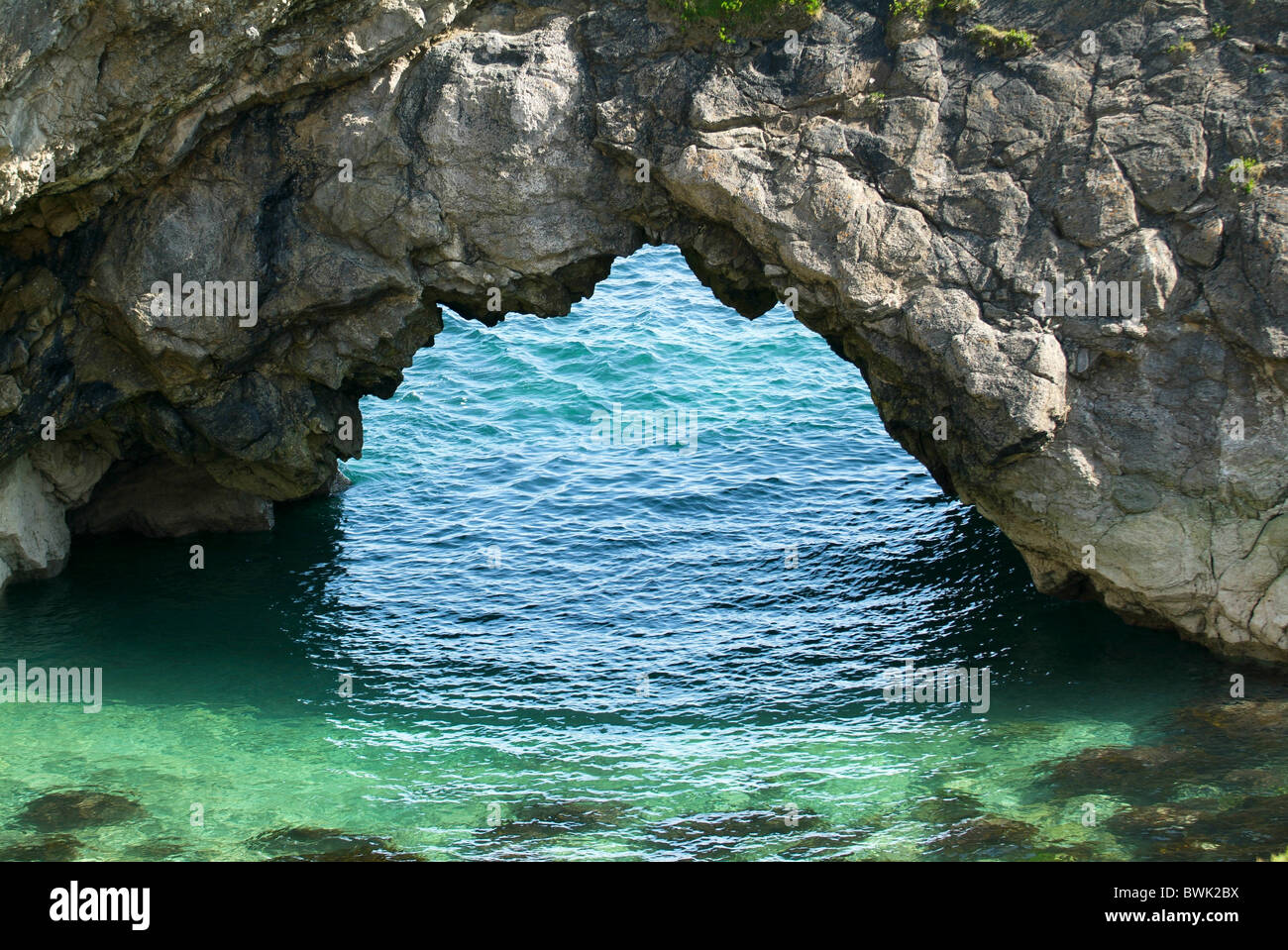 An arch of rock in the sea near Durdle Door in Dorset Stock Photo - Alamy