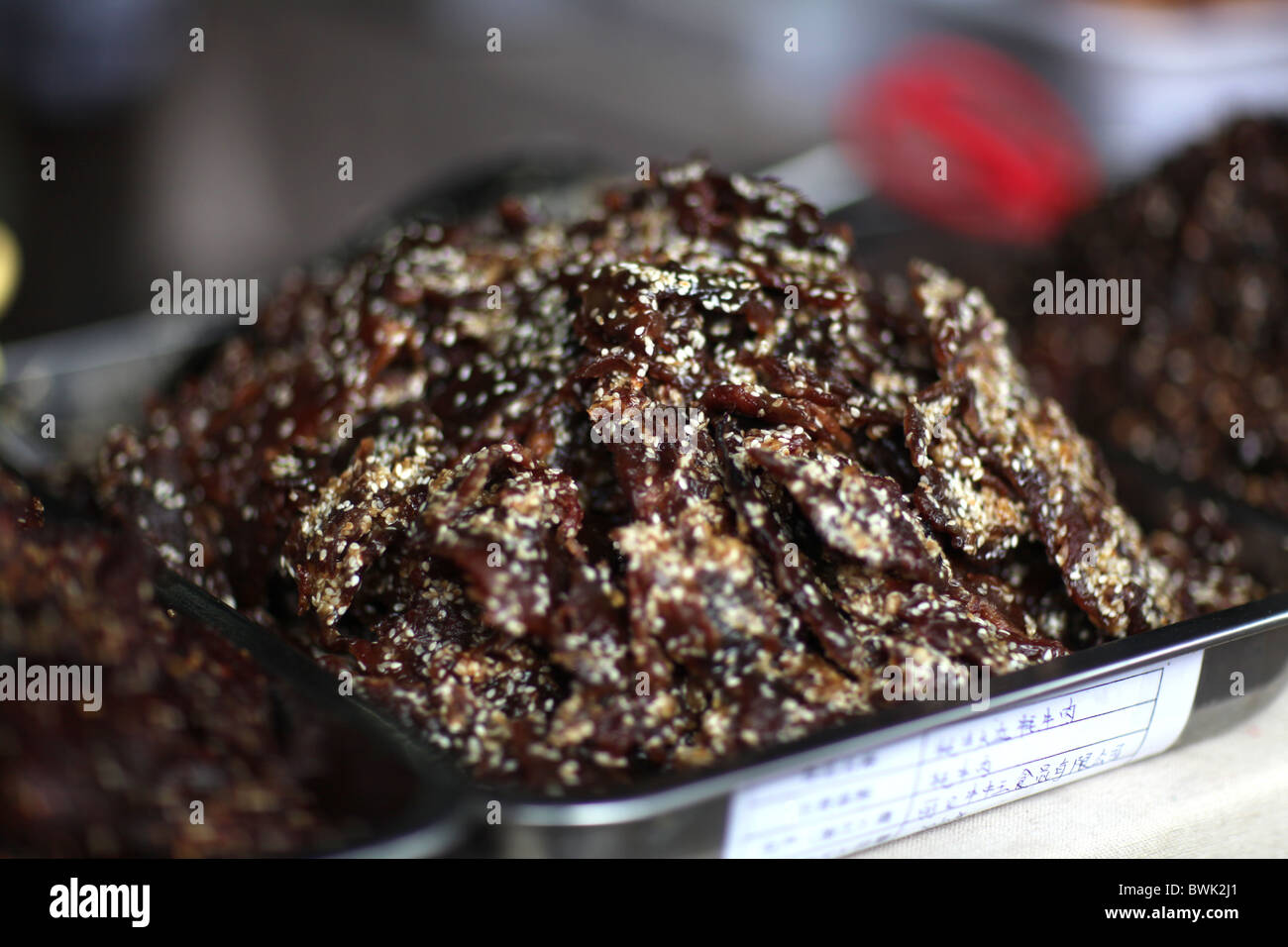Dried yak meat covered in sesame seeds on display in Lijiang Old Town ...