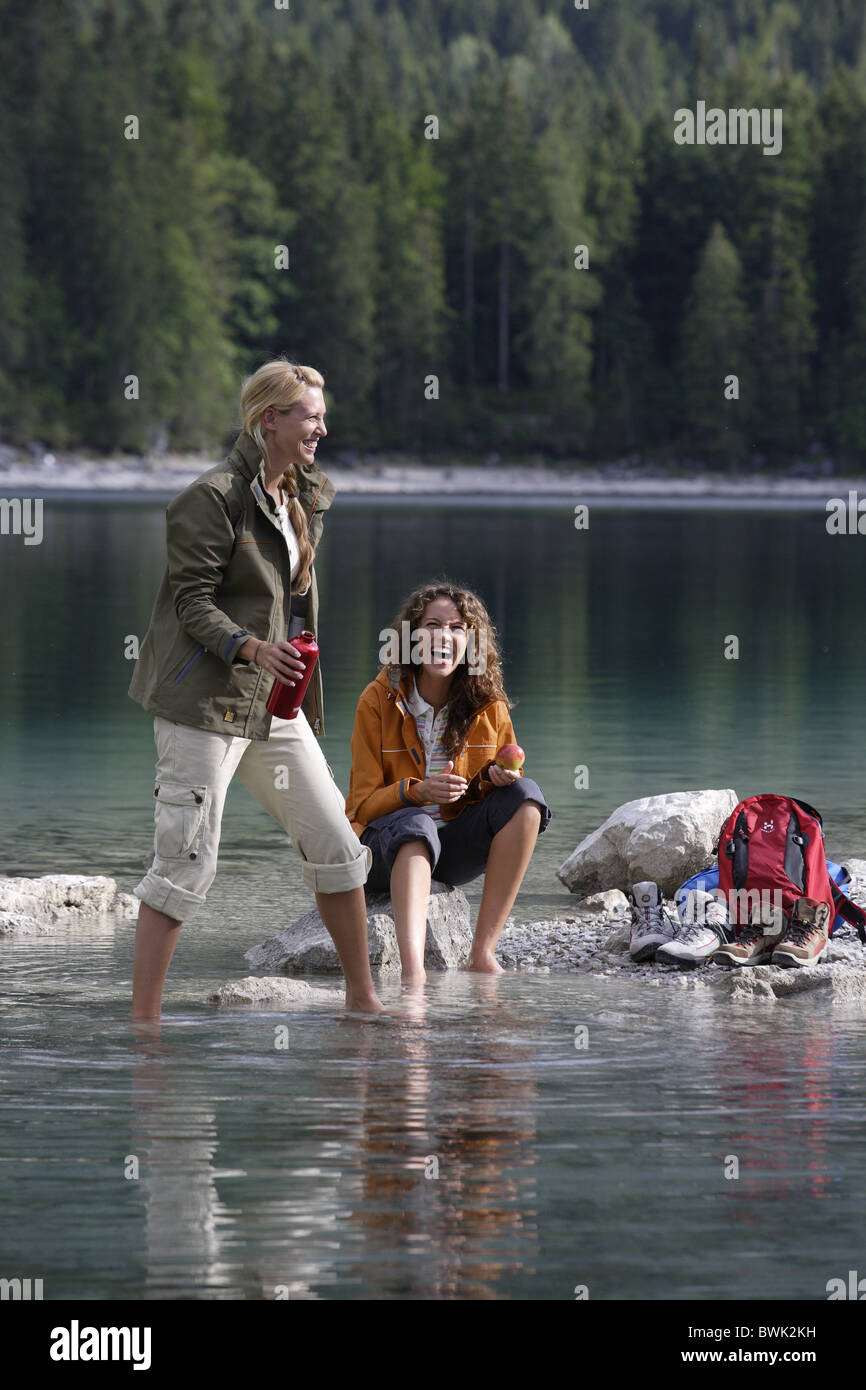 Two young women resting at lake Eibsee, Garmisch-Partenkirchen, Bavaria ...