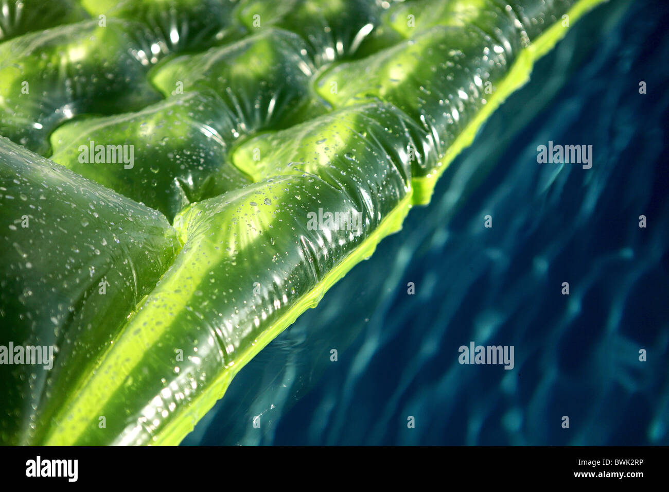 A bright green inflatable raft floating on in a swimming pool Stock ...
