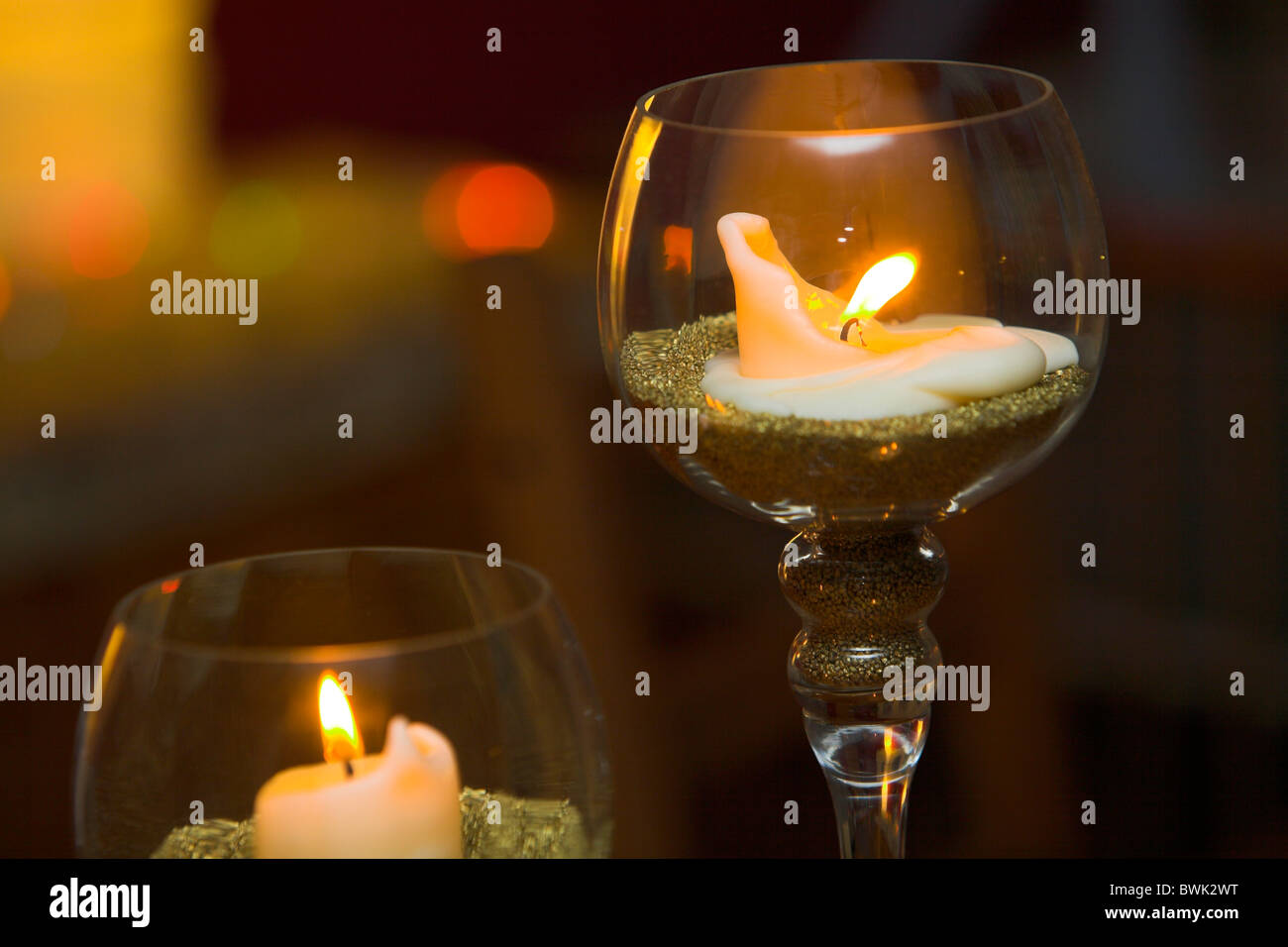 Large yellow white candle almost done burning, standing in a glass vase ...