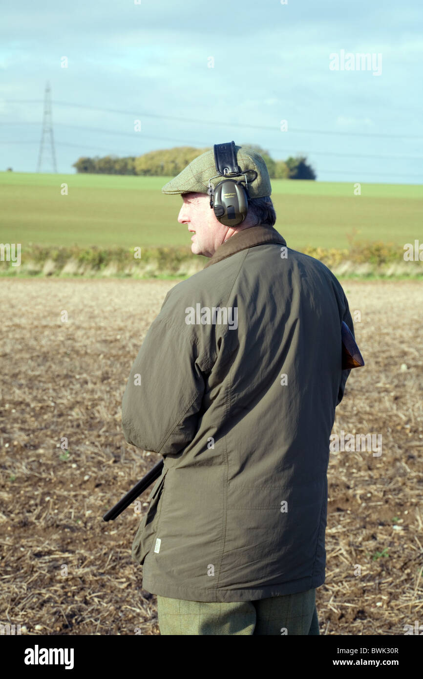 A shooter (gun) waiting for the game birds to rise on a shoot in ...