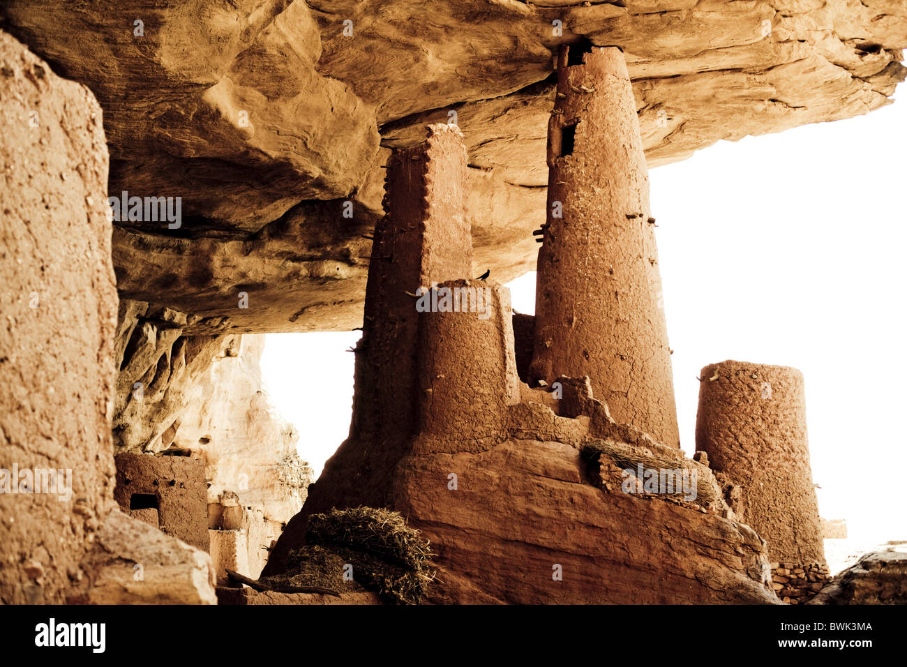 Mud buildings under a rock face at the region of the Dogon people, La ...