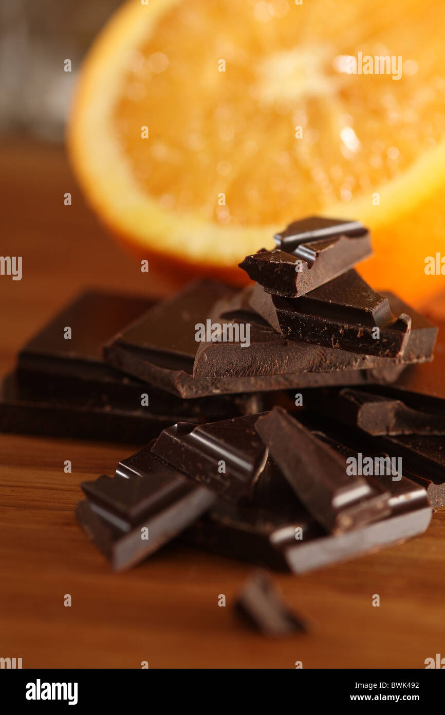 stack of dark chocolate pieces with orange half in background Stock ...