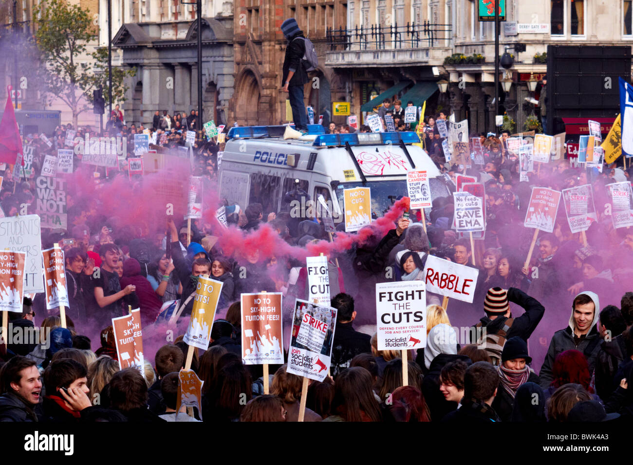 LONDON, UK. A demonstrator lets off a smoke bomb during a student ...