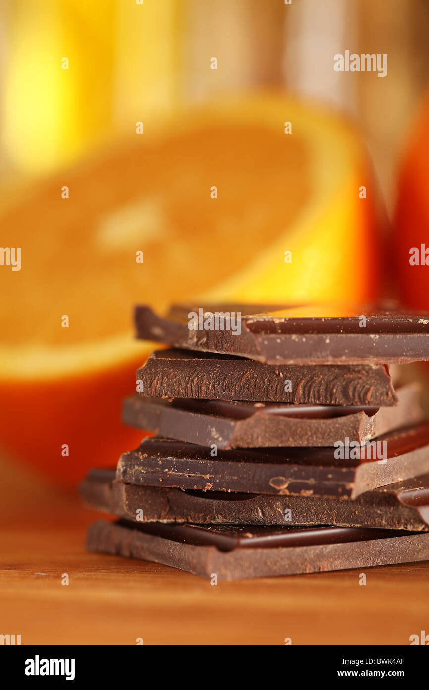 stack of dark chocolate pieces with orange half in background Stock ...