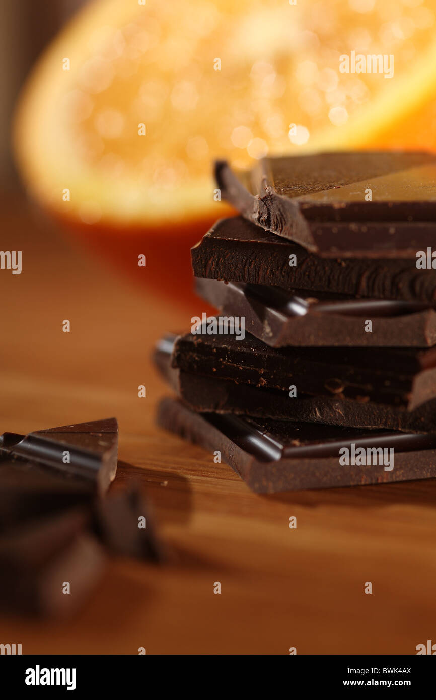 stack of dark chocolate pieces with orange half in background Stock ...