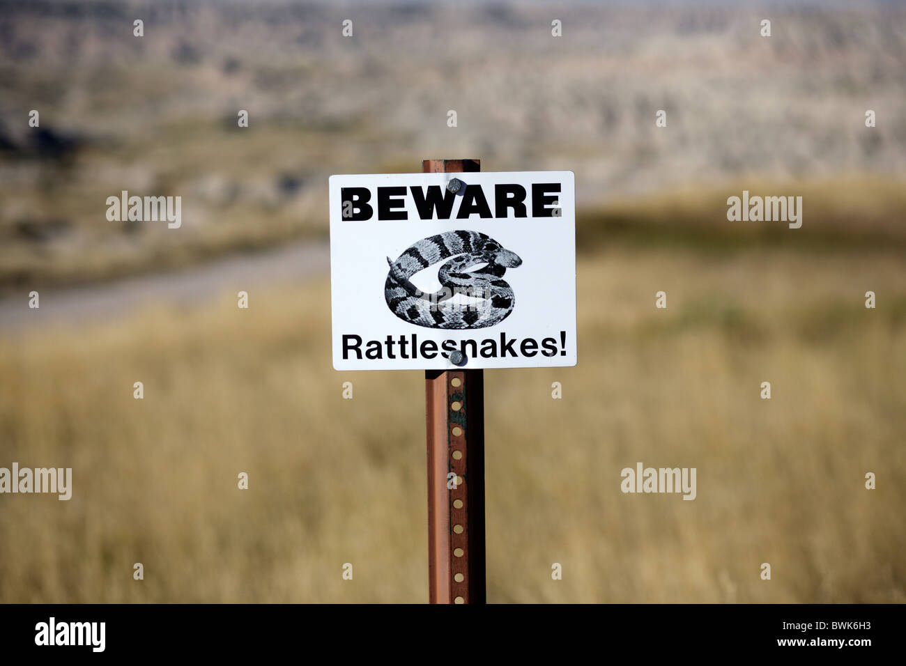 A sign reading Beware Rattlesnakes in the Badlands National Park in ...