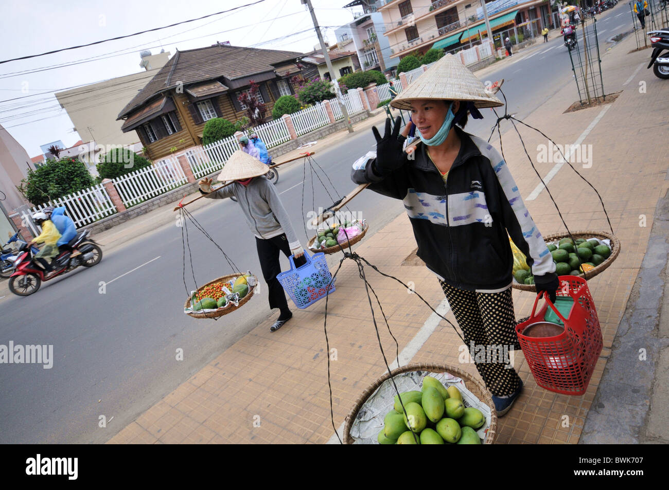 Two women carrying fruit and vegetables, Da Lat in the southern ...