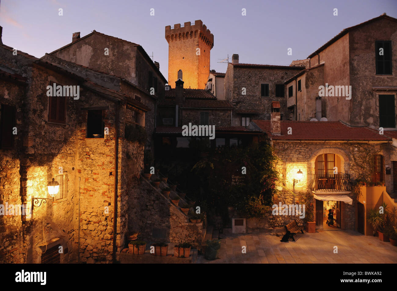 Stone houses and tower at medieval town at dusk, Capalbio, Maremma ...