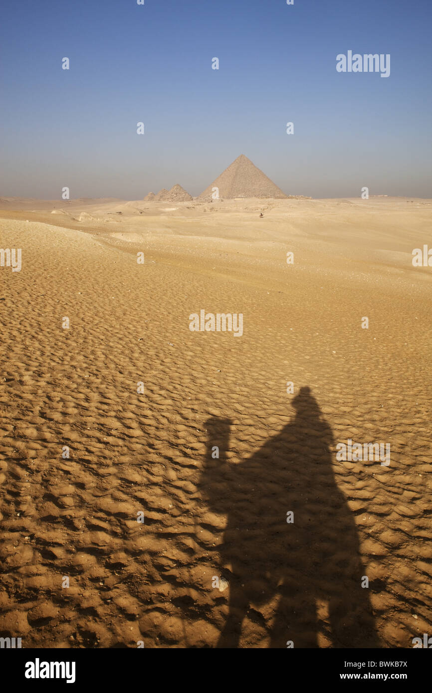 Shadow of a tourist on a camel and the pyramids of Giza, Cairo, Egypt ...