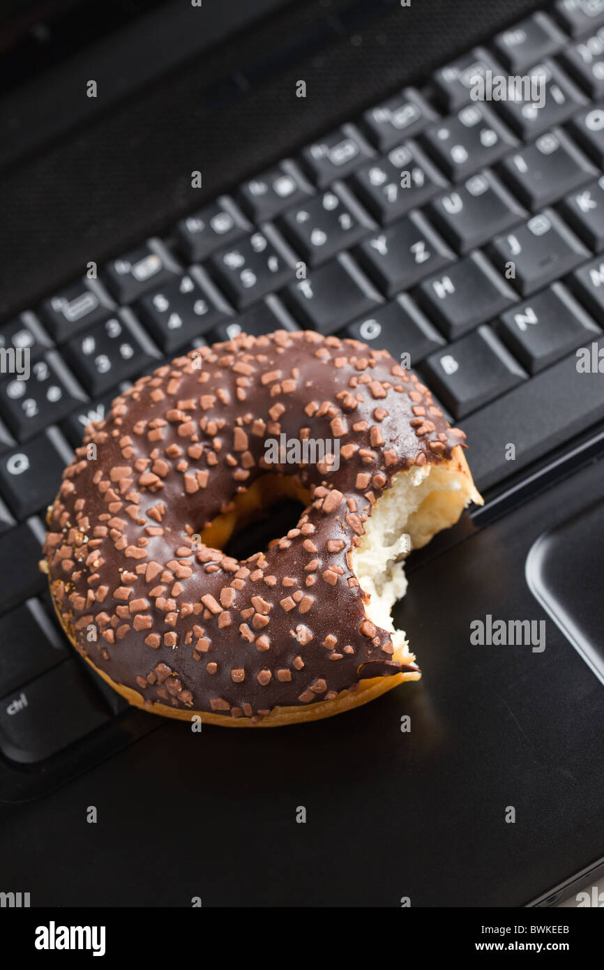 the break in the office . doughnut on laptop keyboard Stock Photo - Alamy