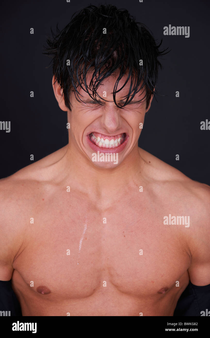 Athletic young man with a bare chest and clenched teeth Stock Photo - Alamy