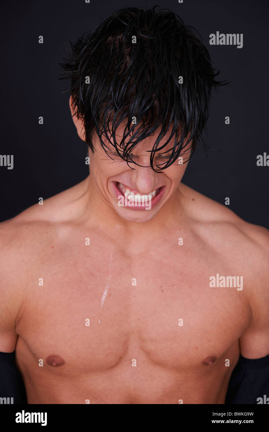 Athletic young man with a bare chest and clenched teeth Stock Photo - Alamy