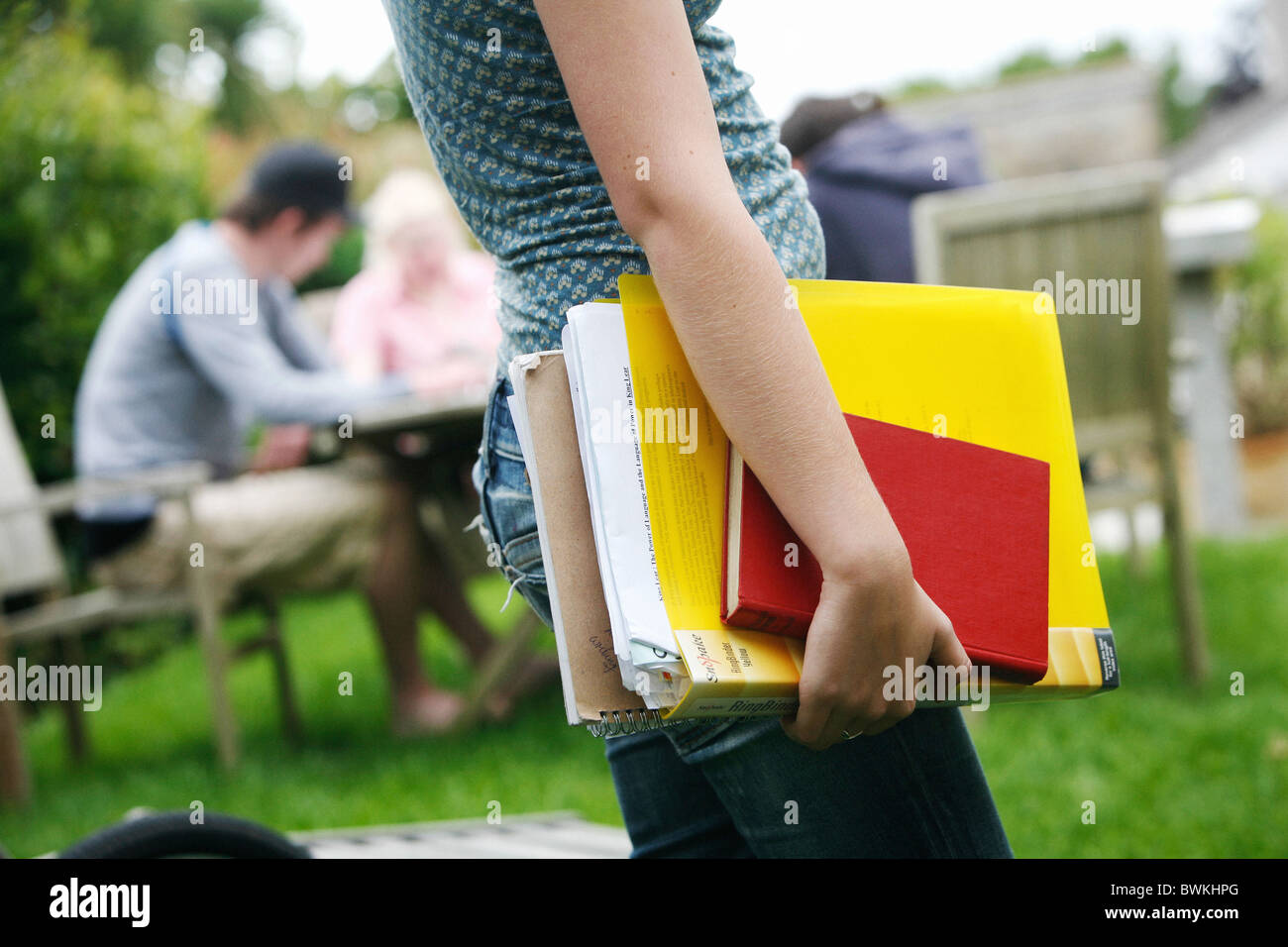Female university student carrying her folders and books for studying ...