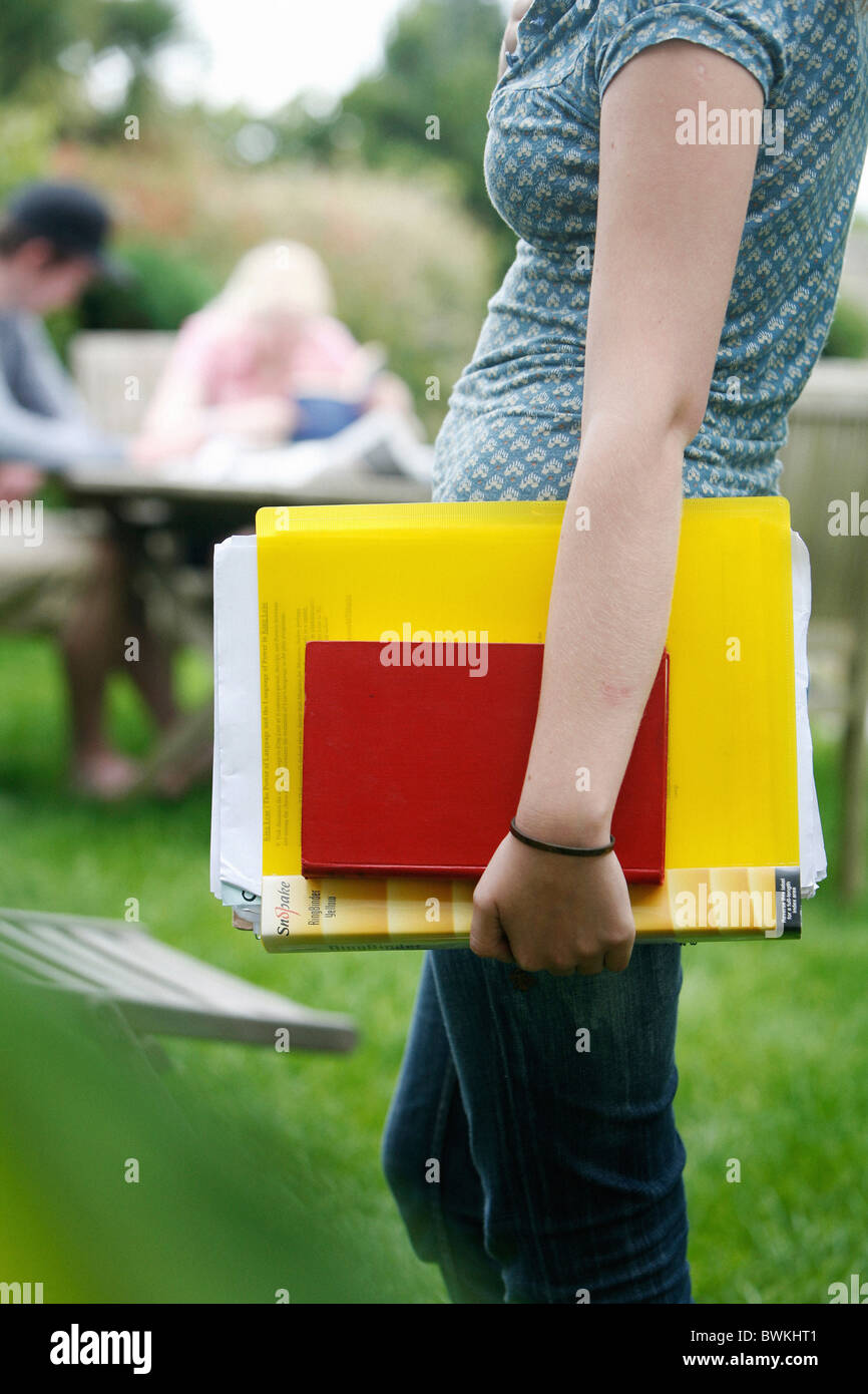 Female university student carrying her folders and books for studying ...