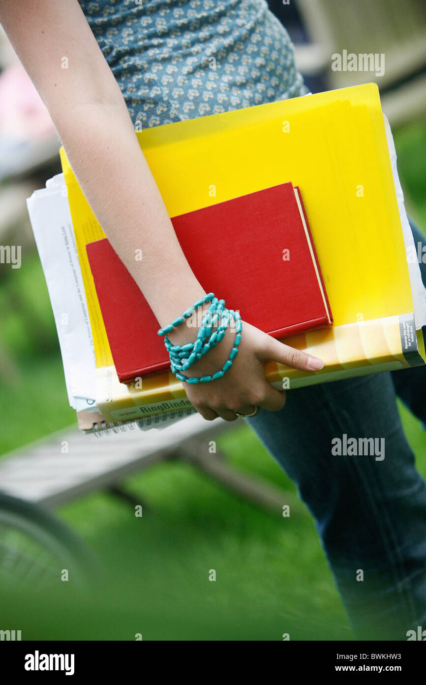 Female university student carrying her folders and books for studying ...