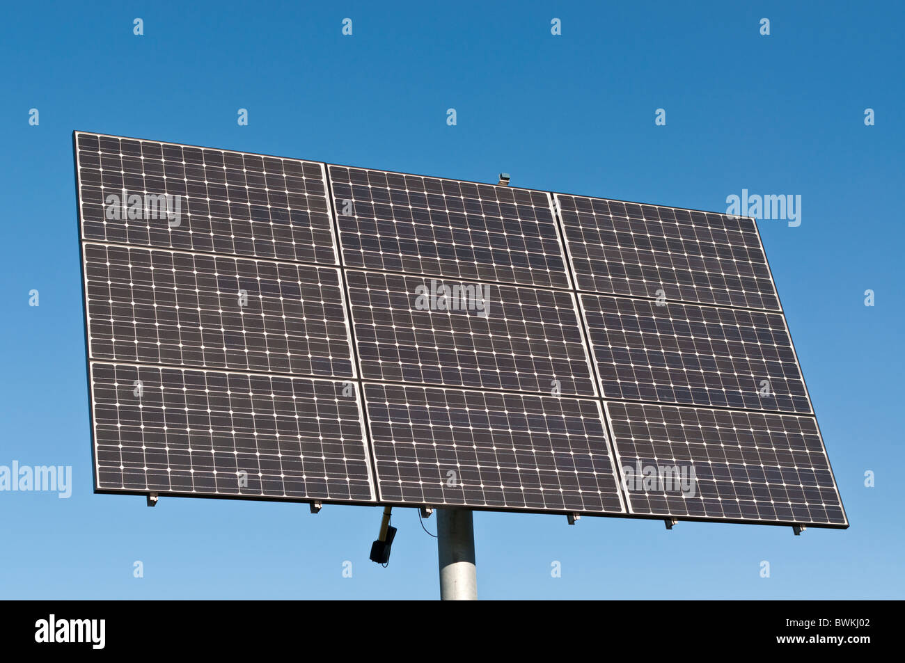 A photovoltaic solar panel array in a park with a deep blue sky in the ...