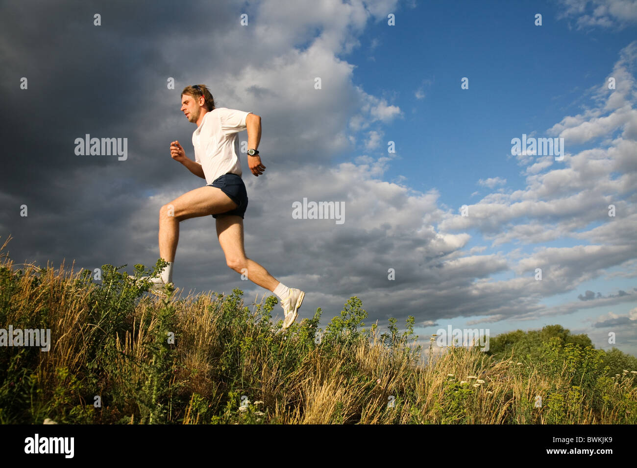 Image of healthy athlete running down green grass Stock Photo - Alamy