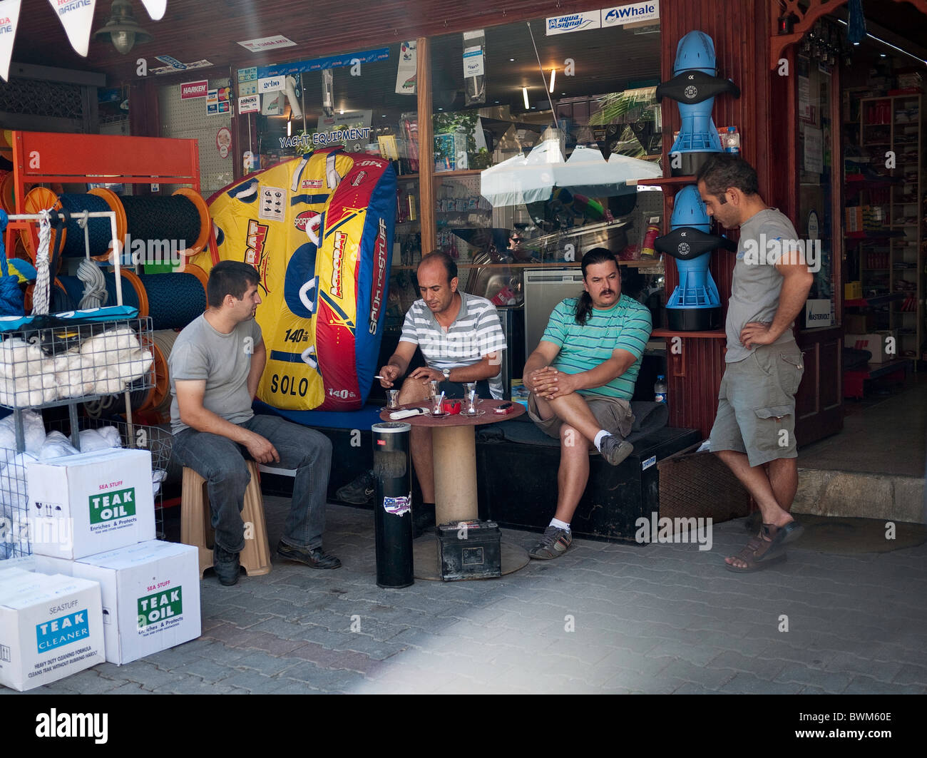 Men sitting outside a boat chandler shop in Gocek Turkey Stock Photo ...