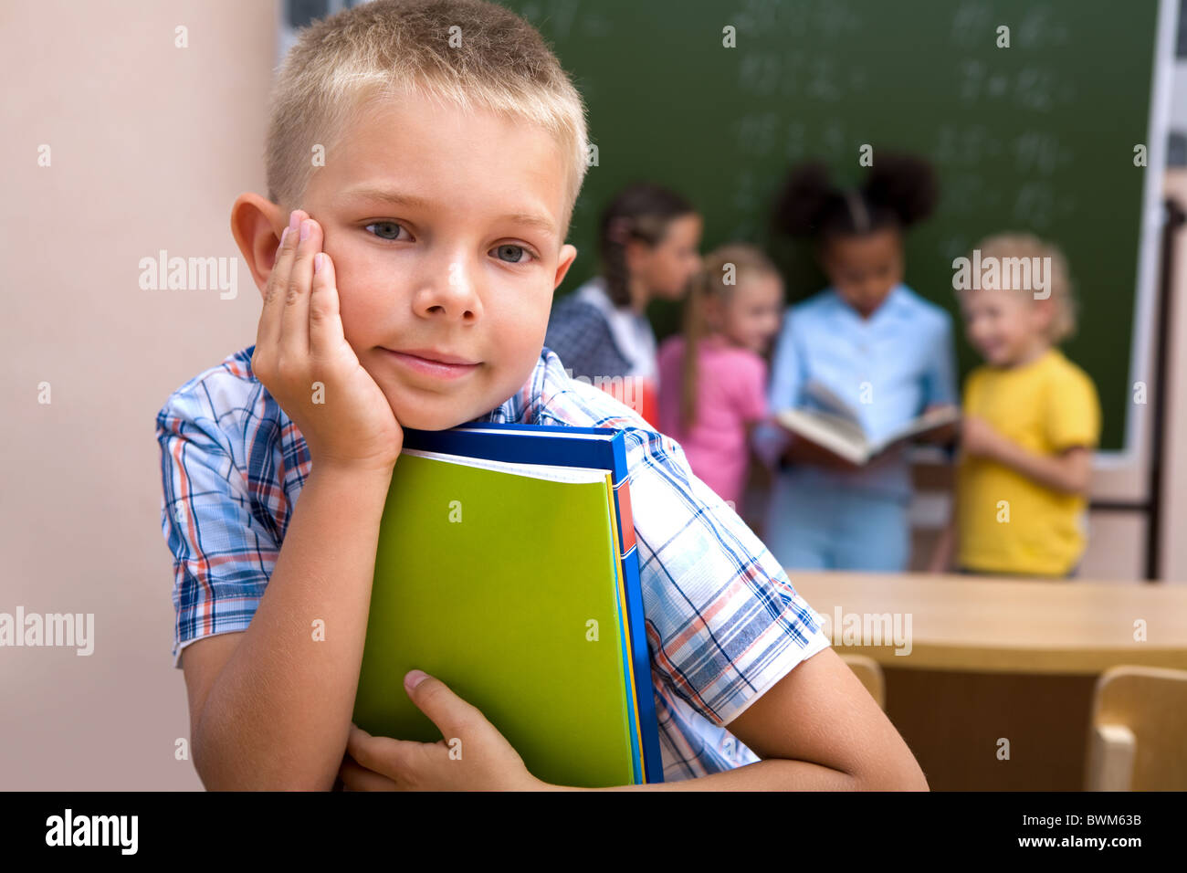 Image of smart schoolboy looking at camera with smile on background of ...