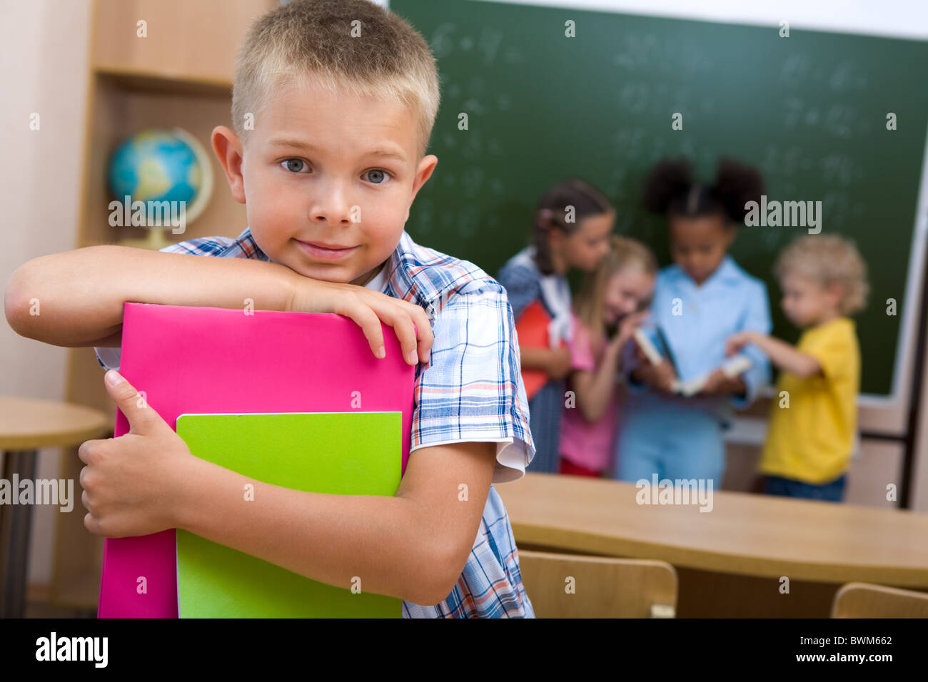 Image of smart schoolboy looking at camera with smile on background of ...