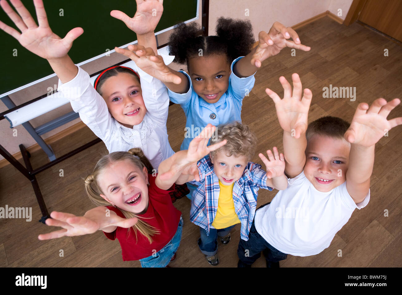 Image of cute schoolchildren looking at camera and laughing with their ...