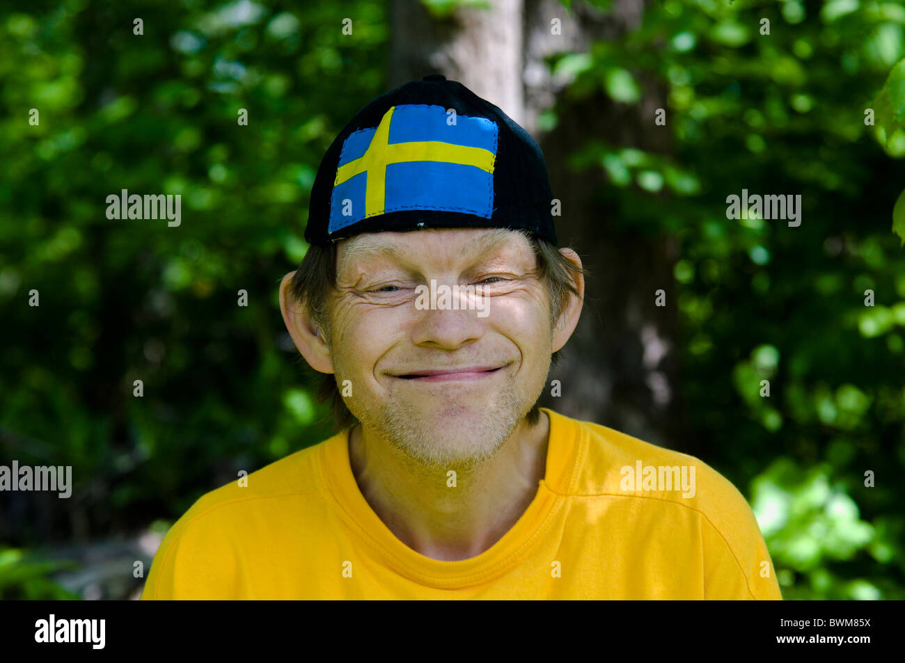 Happy man with a Swedish flag in his hat Stock Photo - Alamy