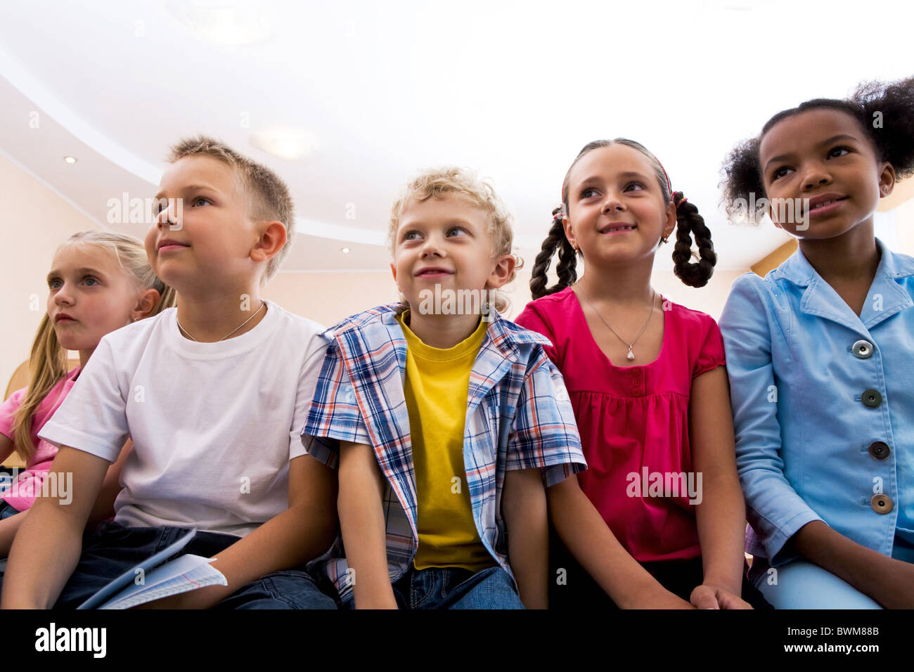 Portrait of pupils looking at lecturer during lesson with attention ...