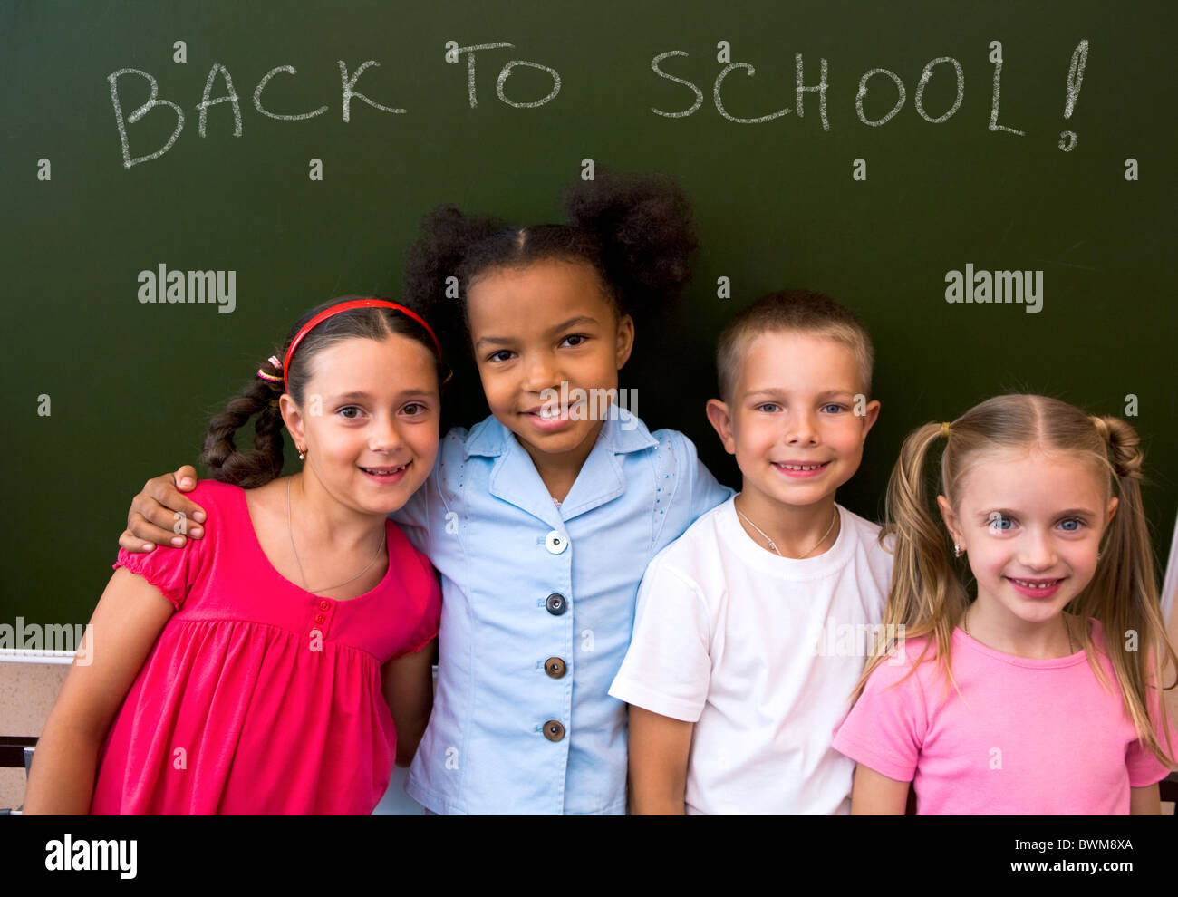Image of clever schoolchildren standing by blackboard and looking at ... Image of clever schoolchildren standing by blackboard and looking at ...