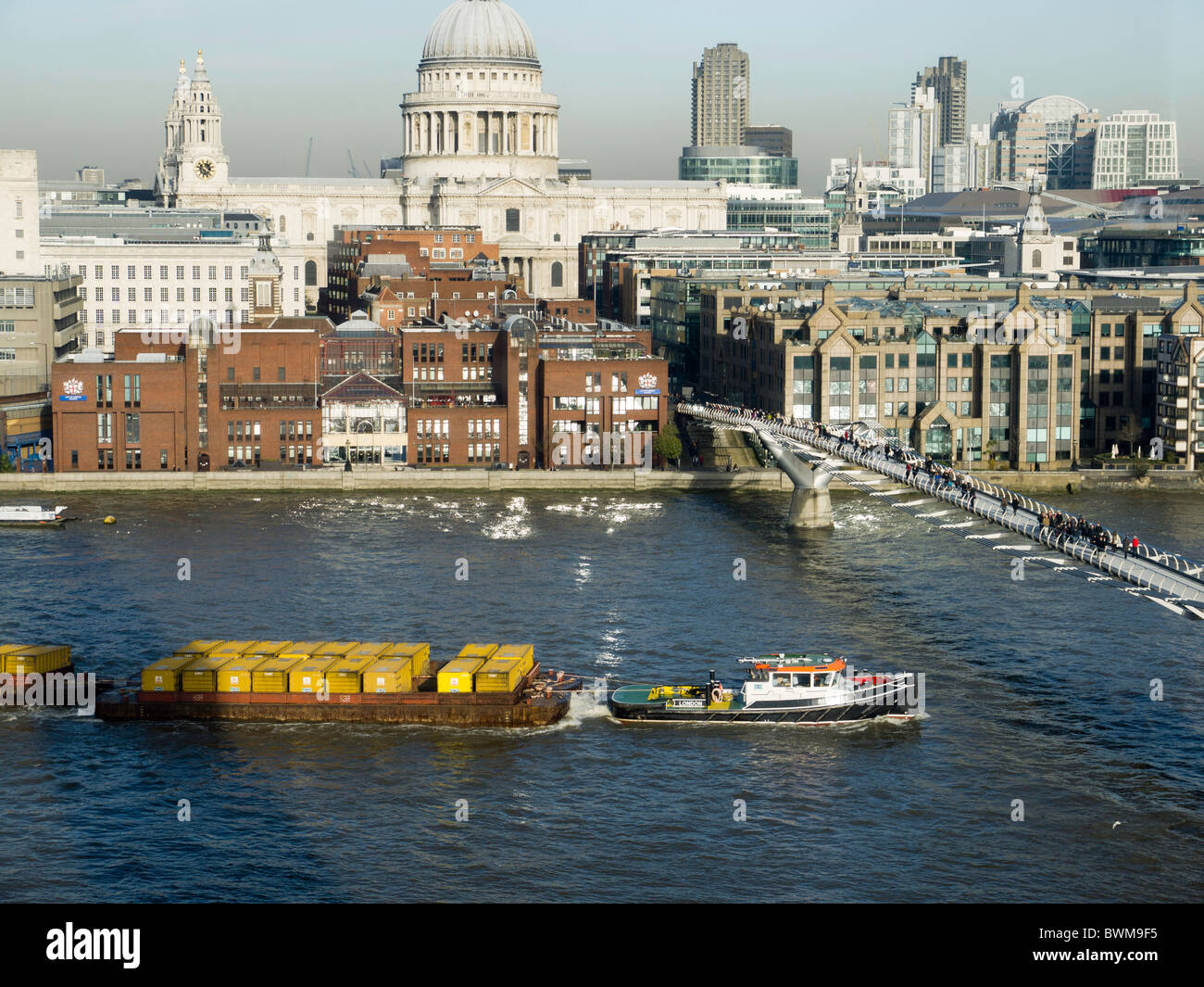 London tugboat moving barges full of containers of compressed garbage ...