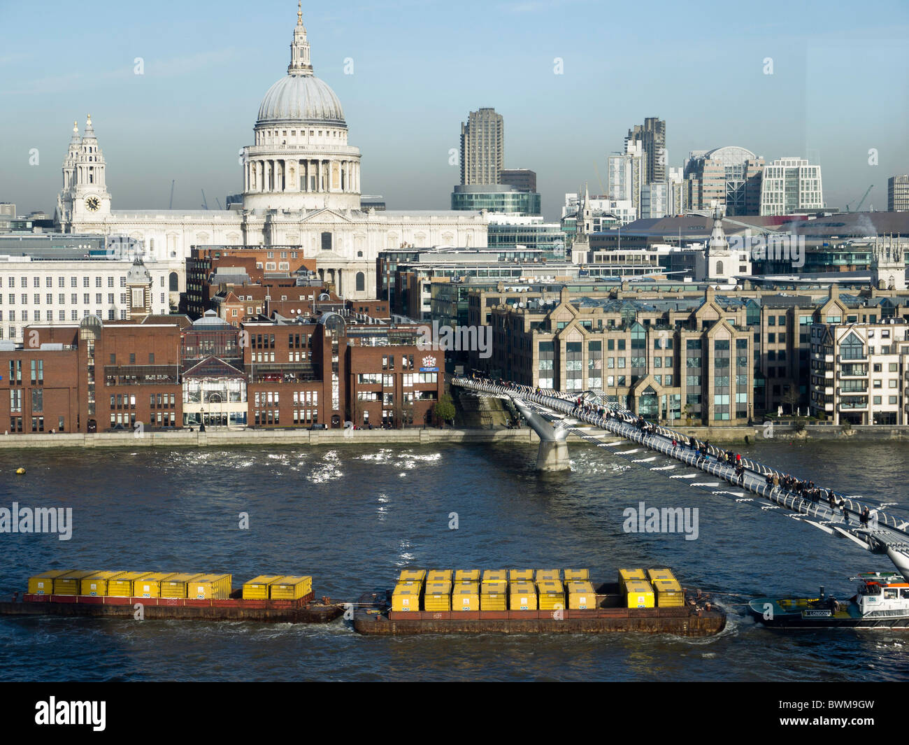 London tugboat moving barges full of containers of compressed garbage ...