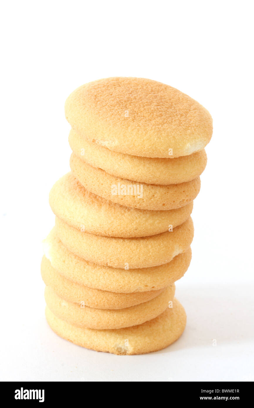 Close up view of several sponge biscuits in a stack on white background ...