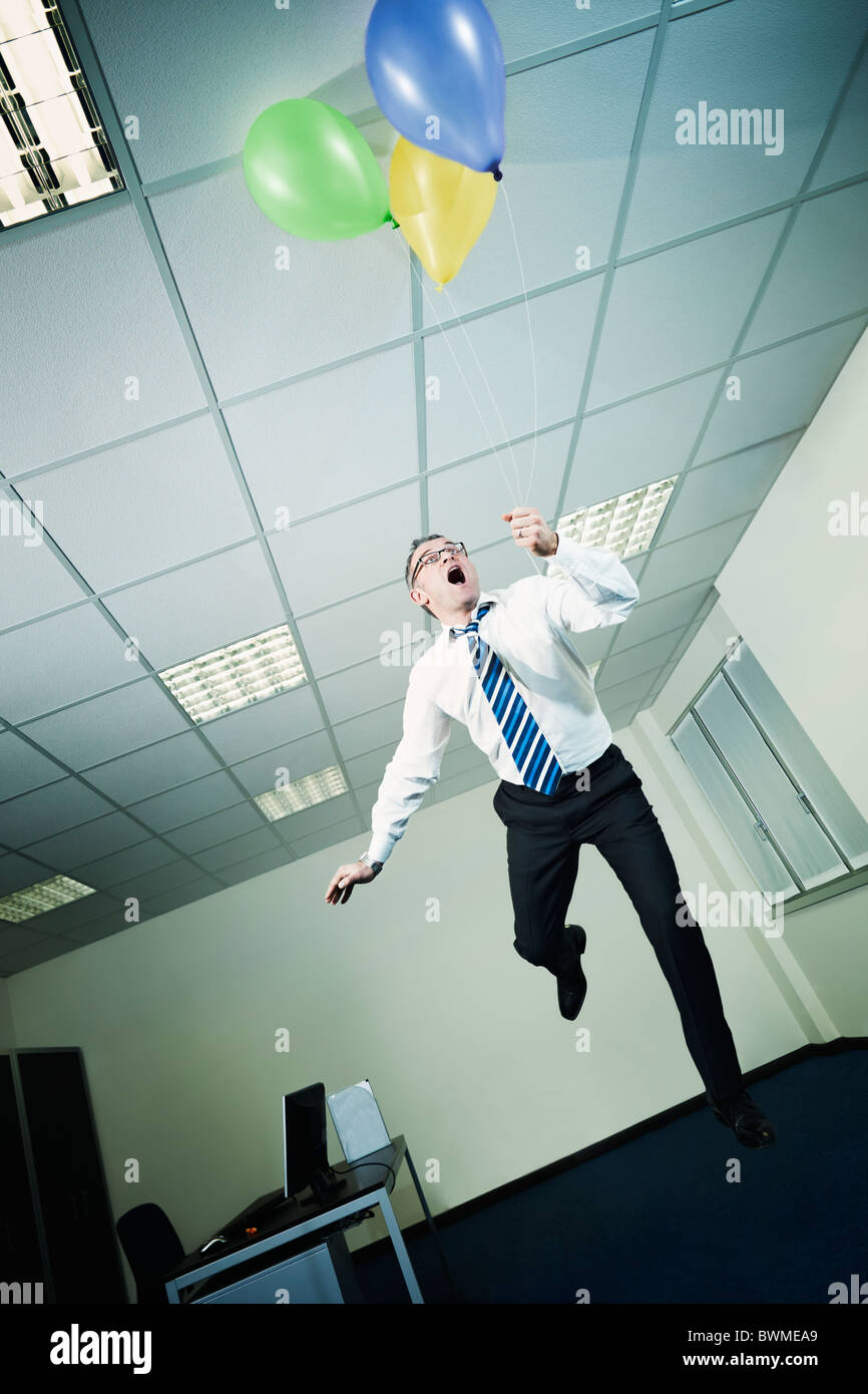businessman flying in office with balloons Stock Photo - Alamy