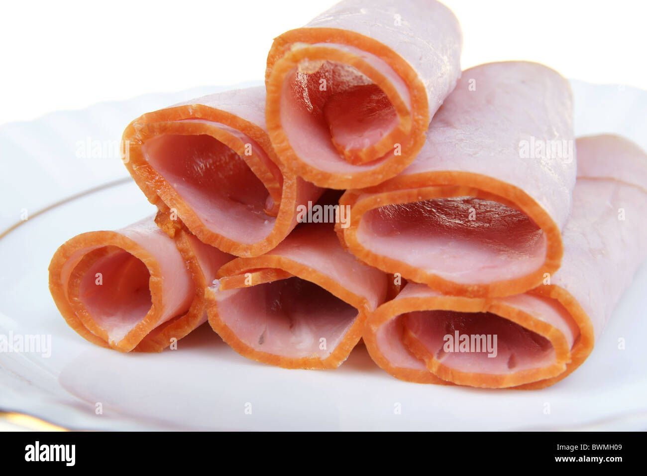 Appetizer a ham slice rolled up on the white plate Stock Photo - Alamy