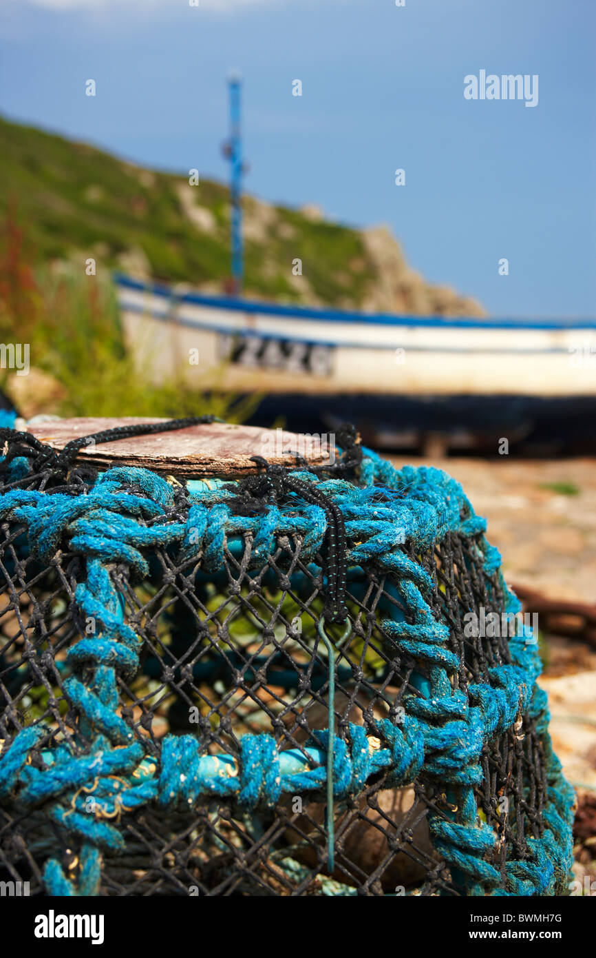 Lobster pots and fishing trawler on the cobbled stone slipway at ...