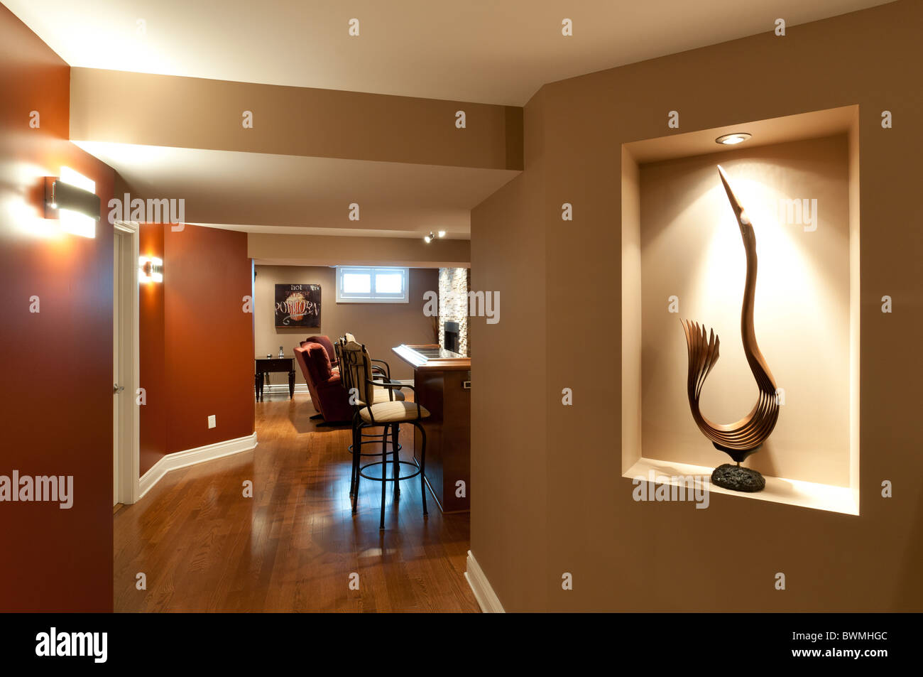 Basement hallway in a luxurious residential home with artwork and bar ...
