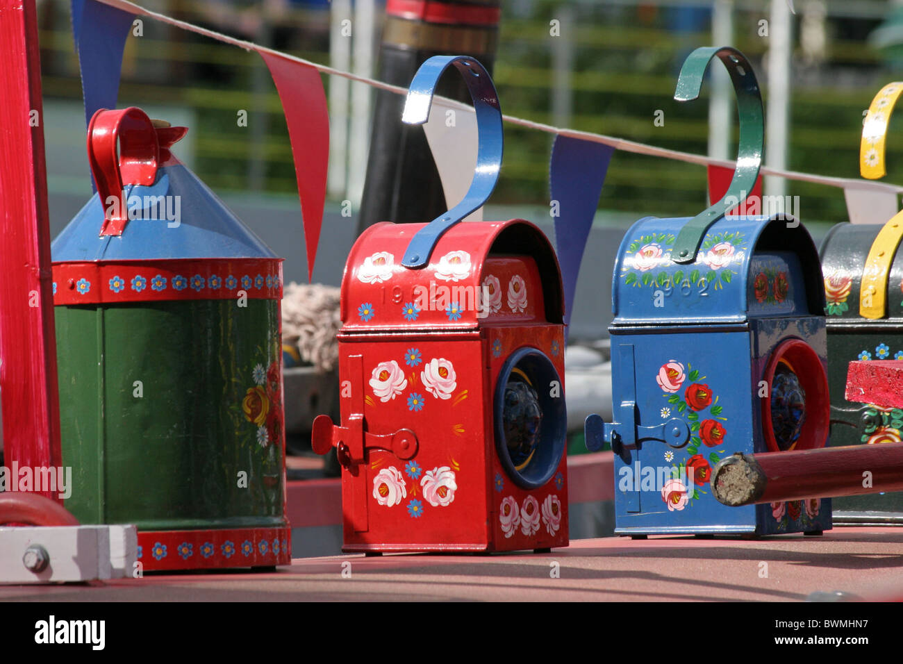 three lanterns traditionally painted with roses lined up on a ...