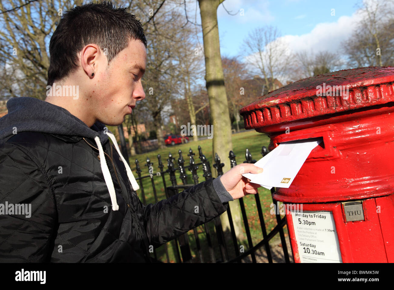 A young man posting letters in a U.K. city Stock Photo - Alamy