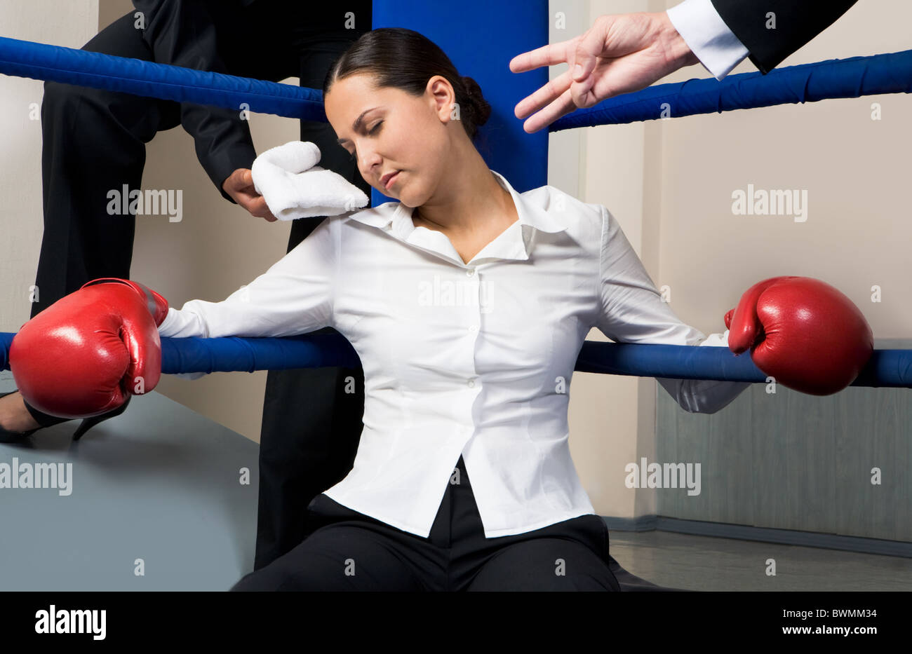 Portrait of tired businesswoman in boxing gloves sleeping on boxing ...