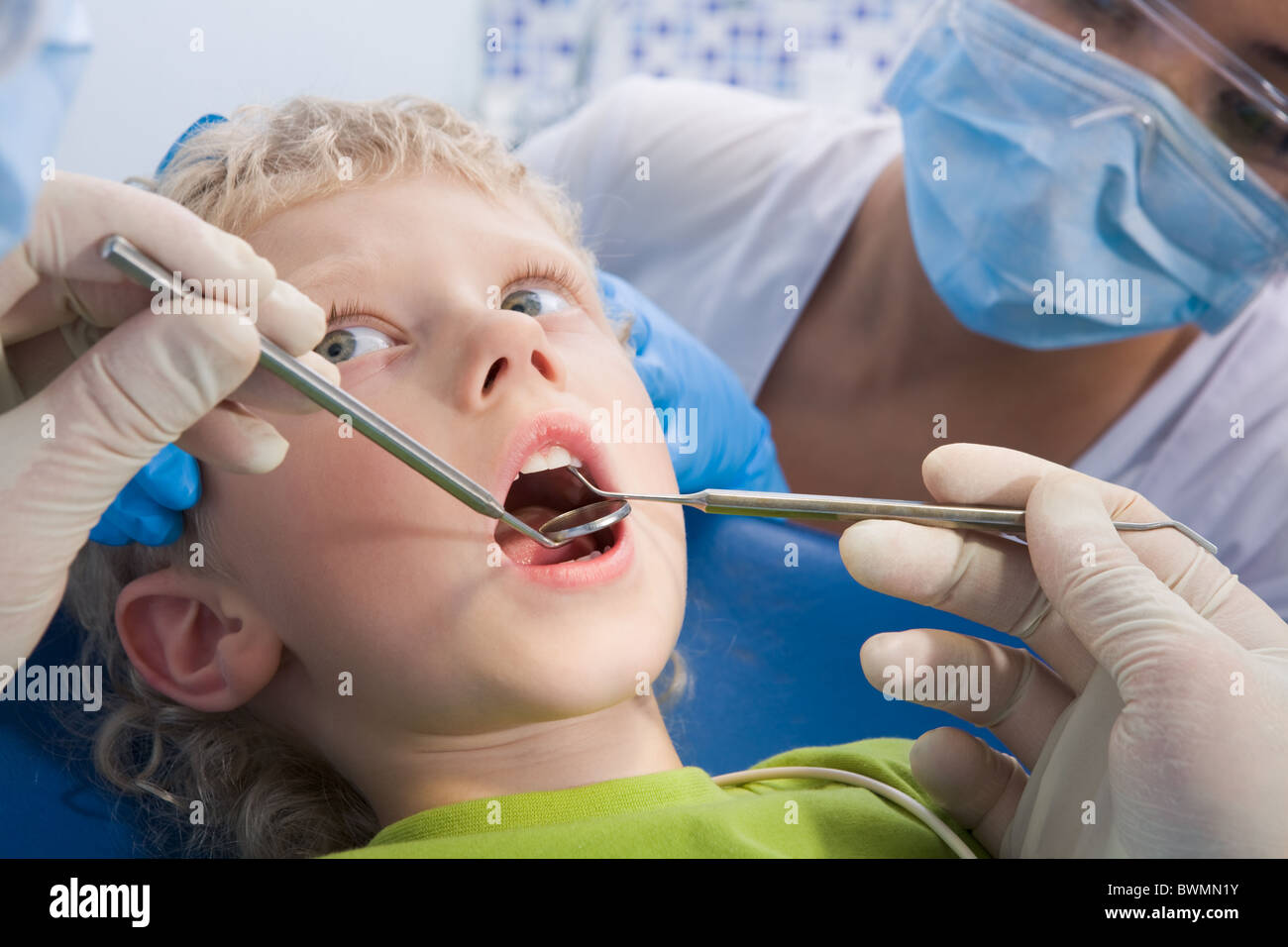 Photo of little boy having mouth checkup in dental clinic Stock Photo ...