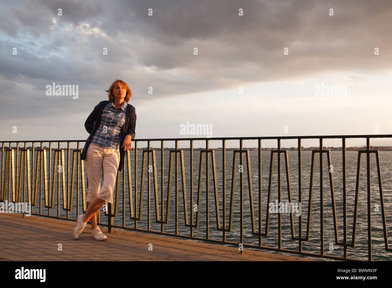 Woman on the pier at sunset Stock Photo - Alamy