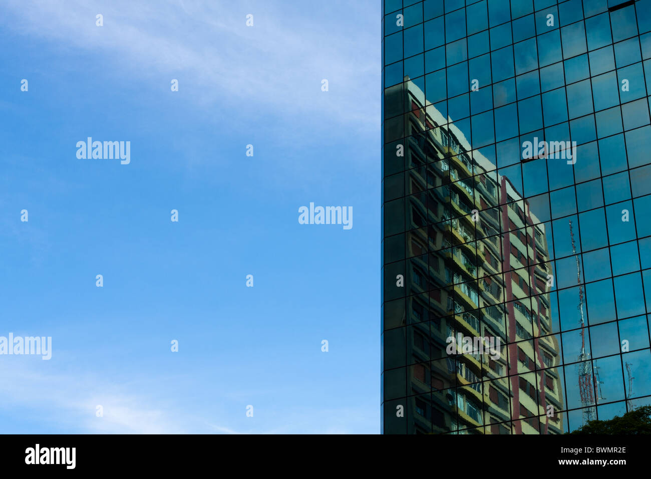 Building reflection in glass windows against blue sky background ...