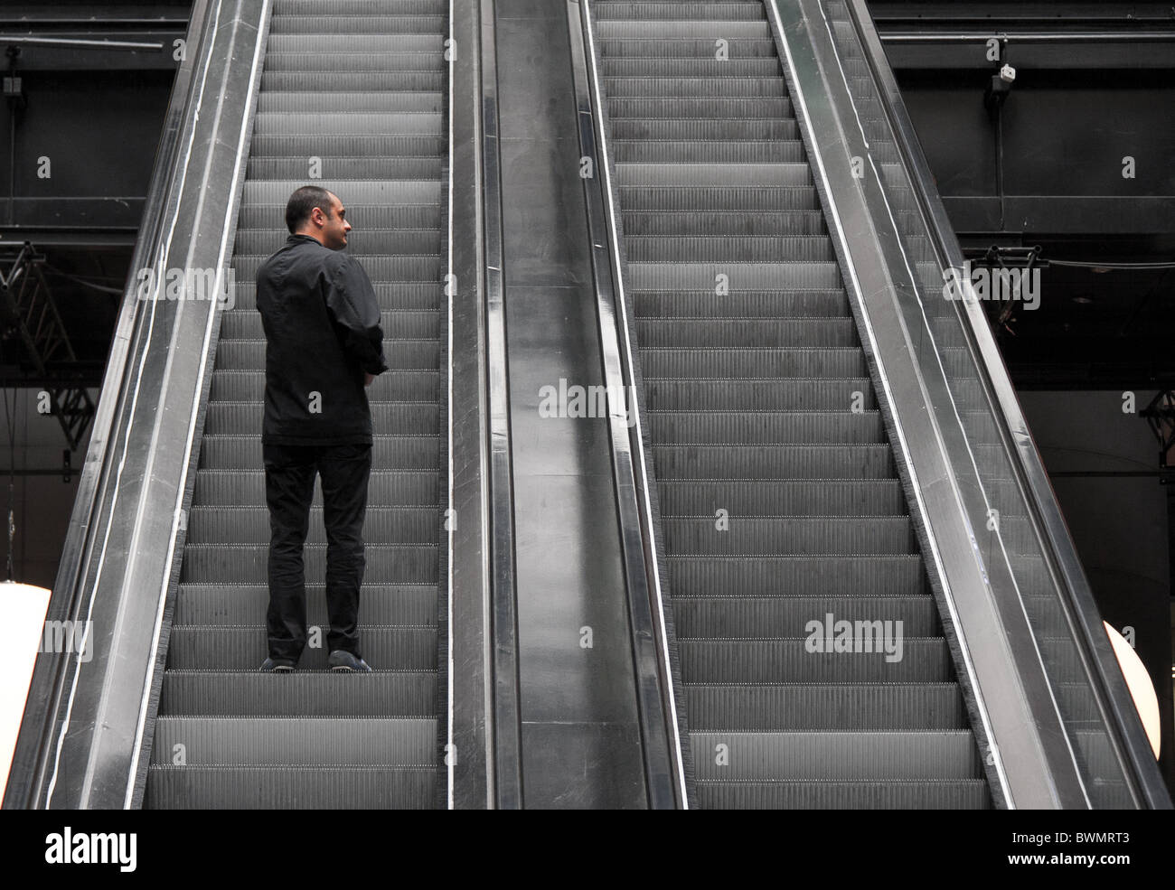 Man ascending on escalator Stock Photo - Alamy