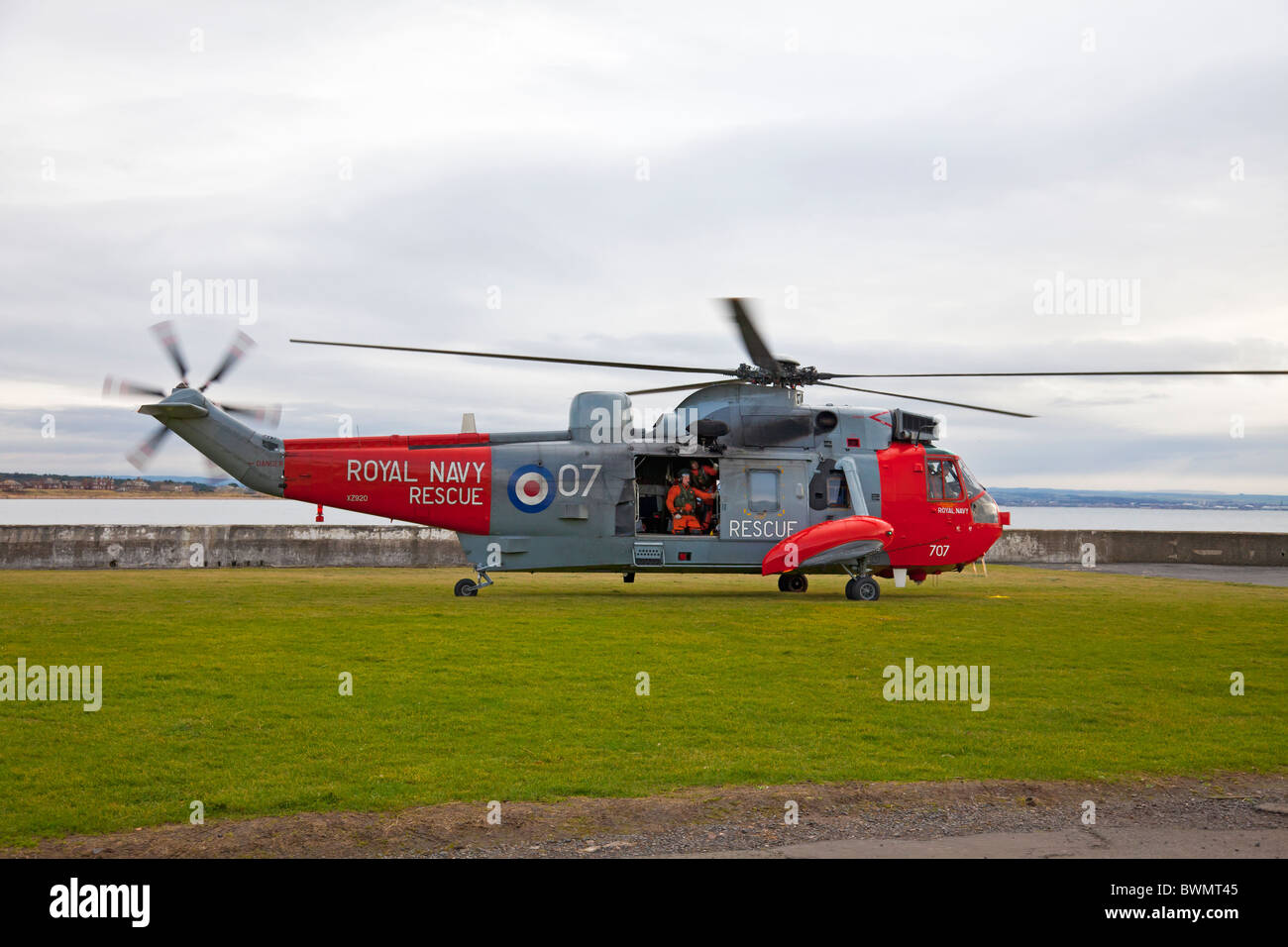 Royal Navy rescue helicopter on grass at the shorefront in Troon, South ...