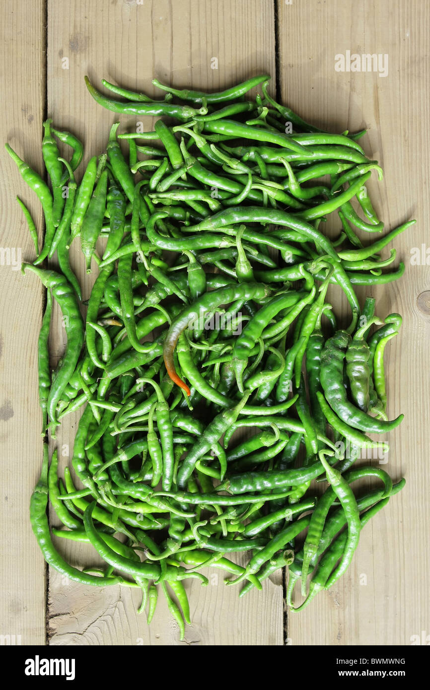 Green, hot chilli on the wooden floor Stock Photo - Alamy