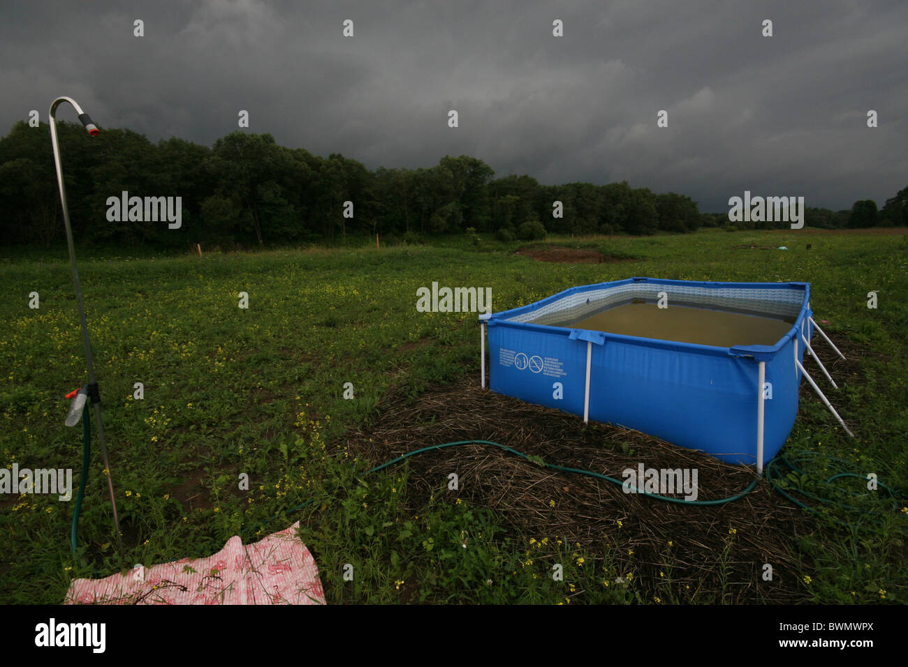 Swimming pool in the meadow at thunderstorm Stock Photo - Alamy